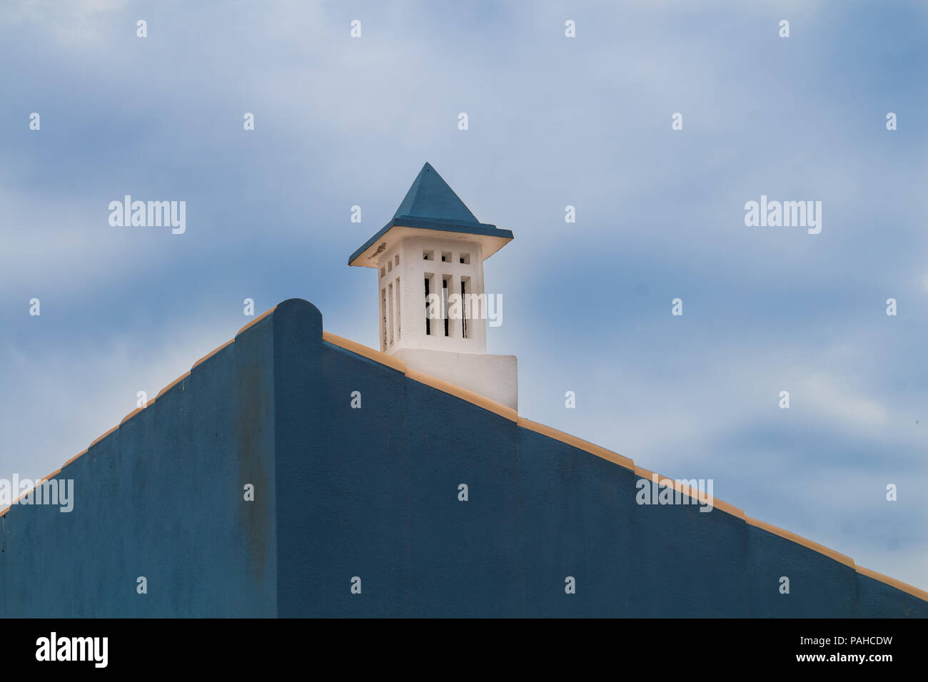 Side wall of a house painted blue with a triangular shape. Traditional ...