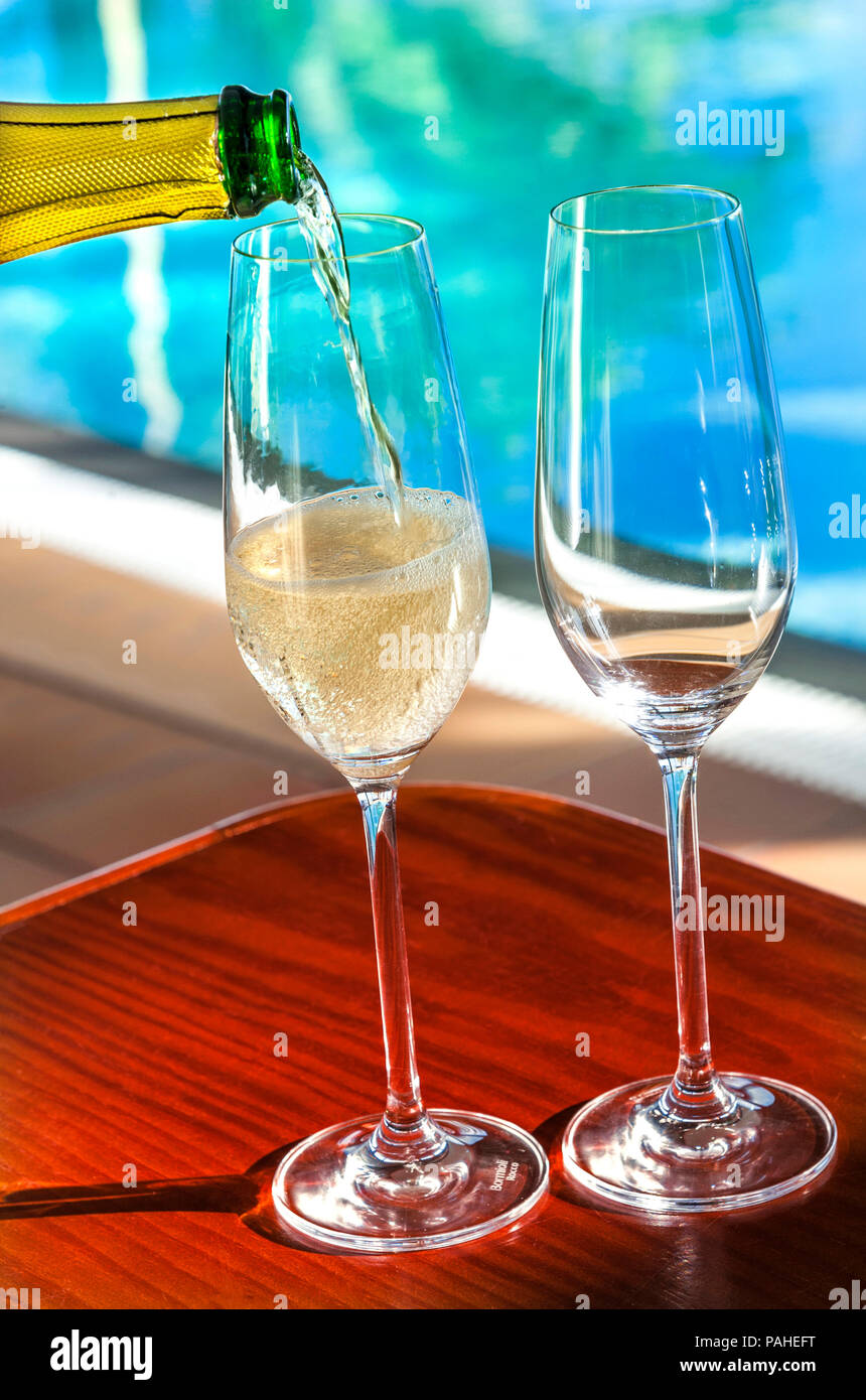 Pouring chilled glasses of Champagne Cava on sunlit vacation sunny ...