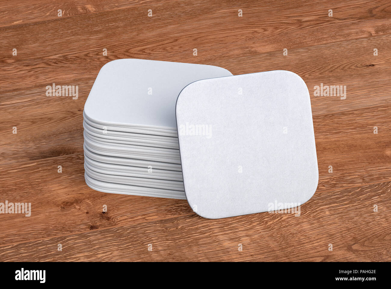 White square beer coasters on wooden background with clipping path ...