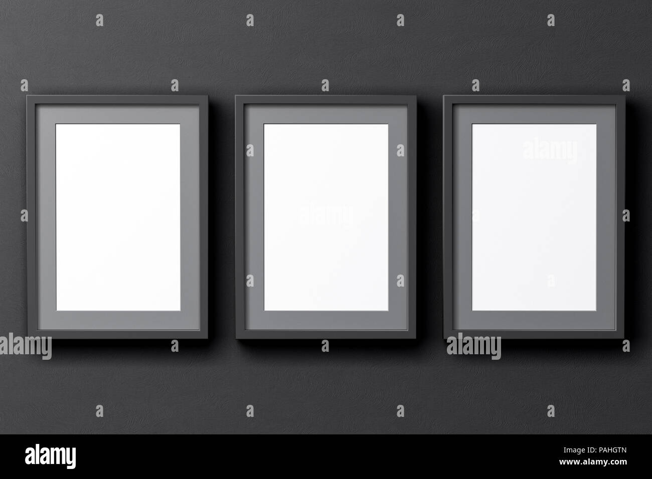 Blank three vertical posters on the black wall with dark frame and ...