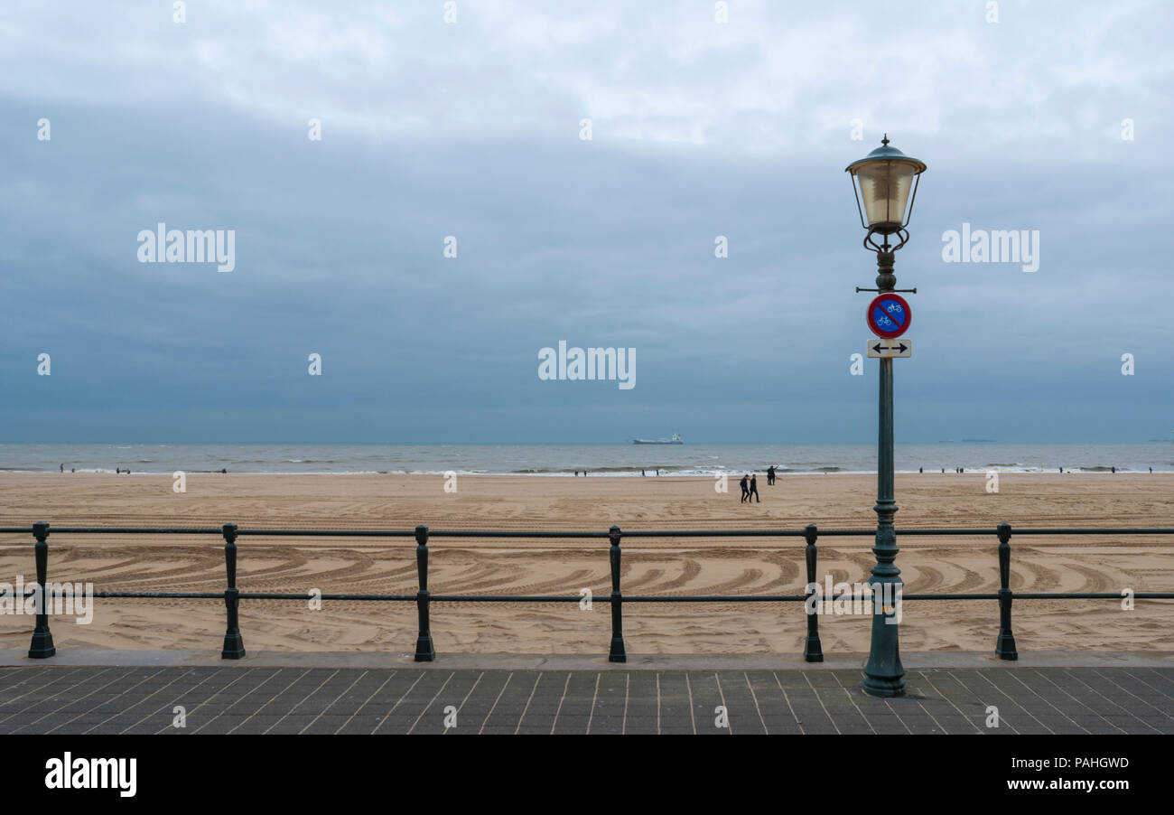 View of an empty beach in off-season, with a lamppost and handrails on ...