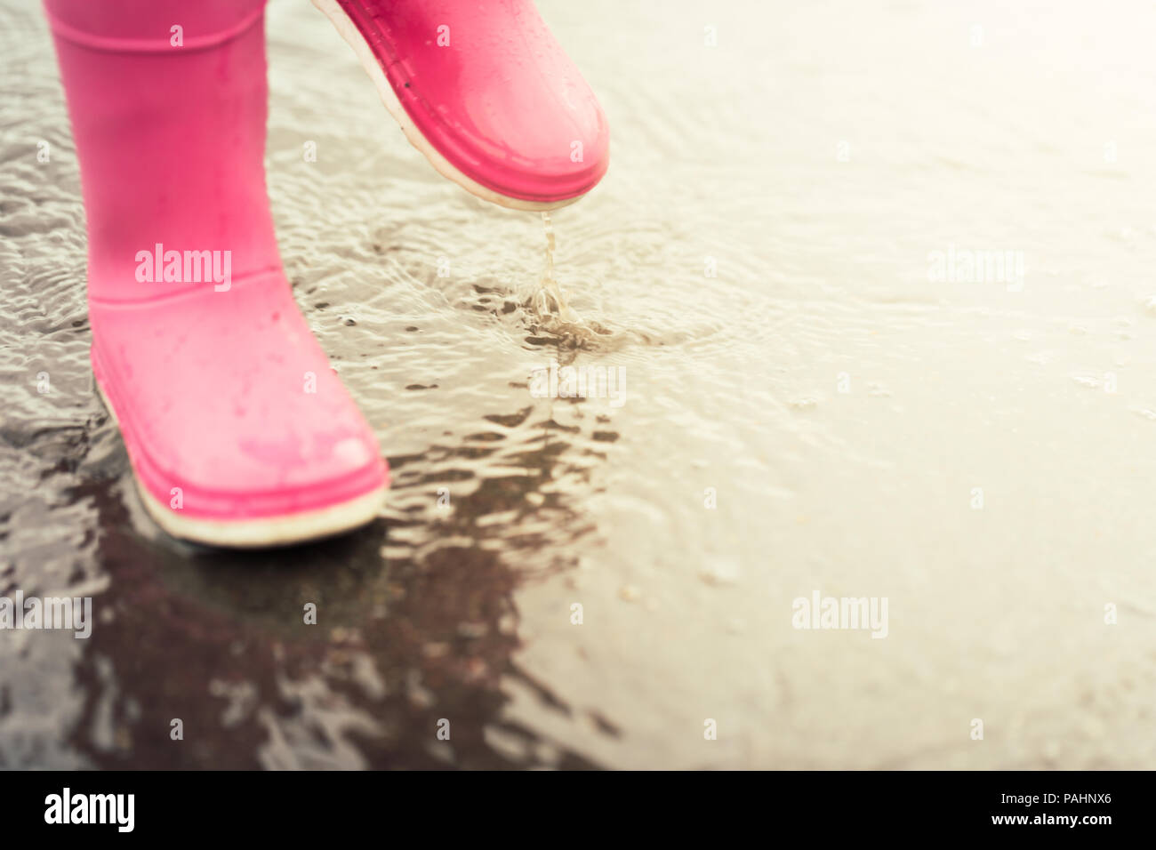Kid child jumping puddle water splash hi-res stock photography and ...