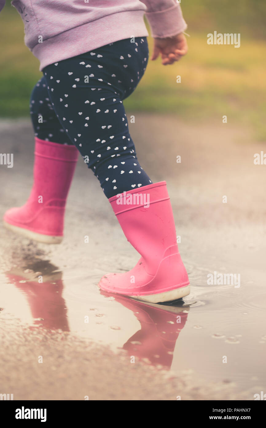 Kid child jumping puddle water splash hi-res stock photography and ...