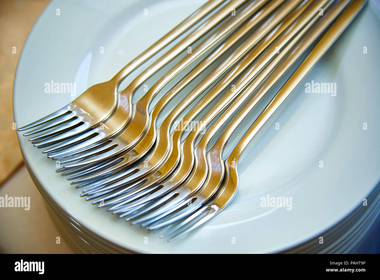 The forks lies on the stack of plates close-up Stock Photo - Alamy