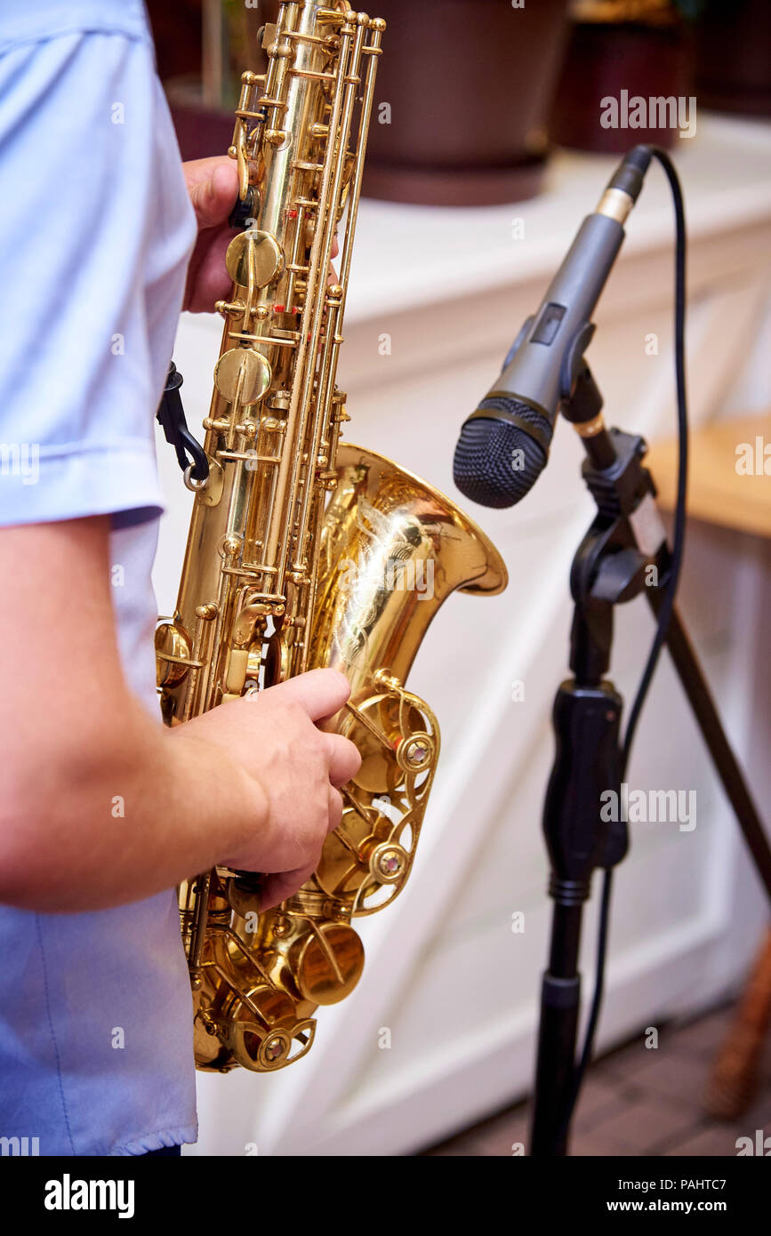 Saxophone in the hands of a musician Stock Photo - Alamy