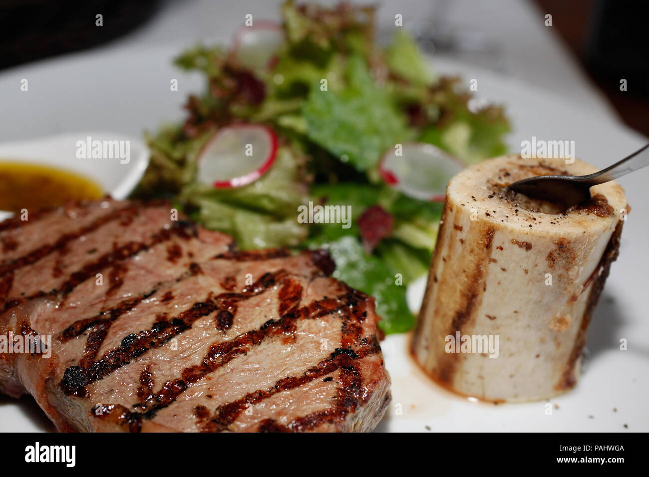Grilled beef steak and bone marrow with salad, close up Stock Photo - Alamy