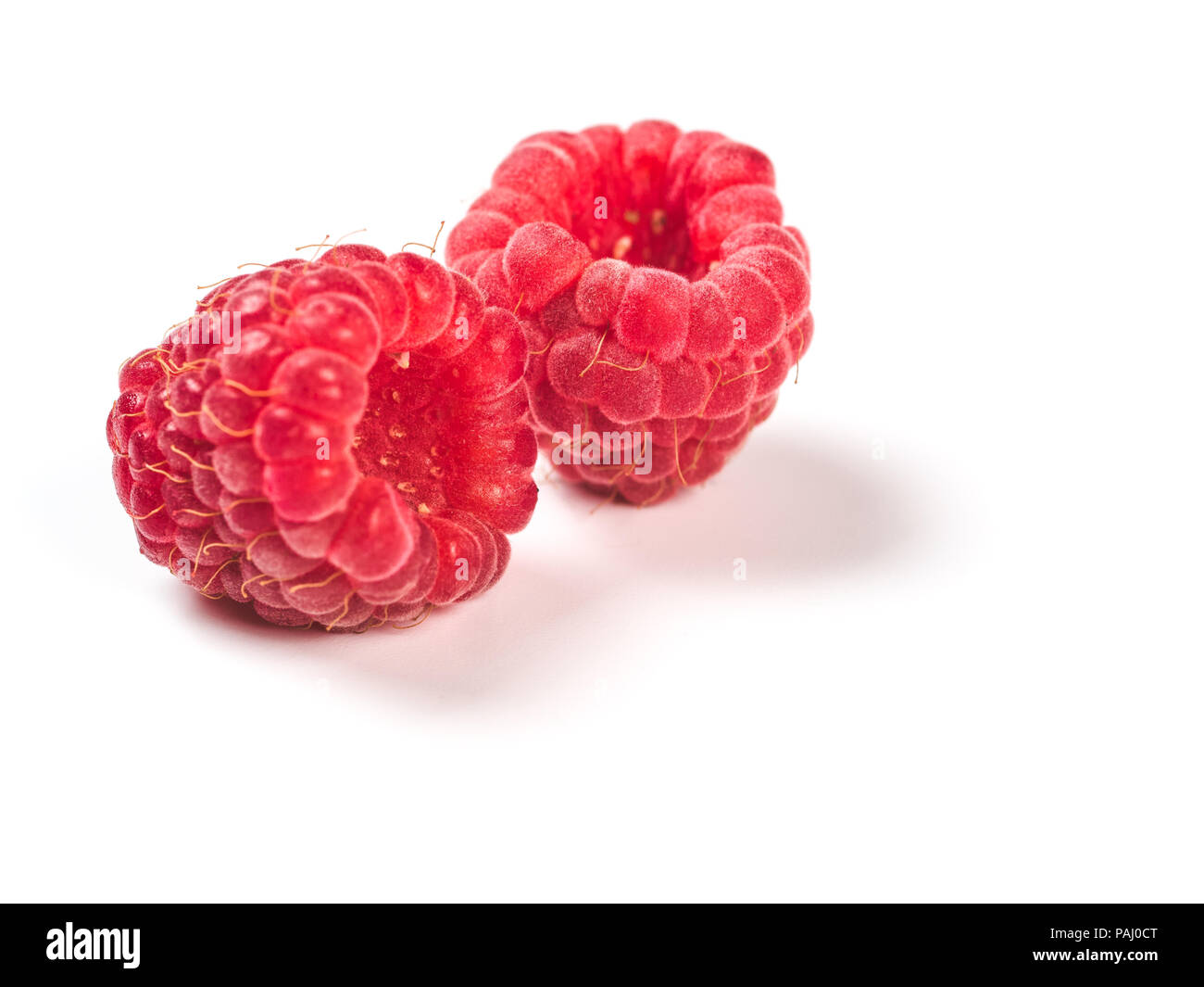 Close up view of two ripe red raspberry berries on white background ...