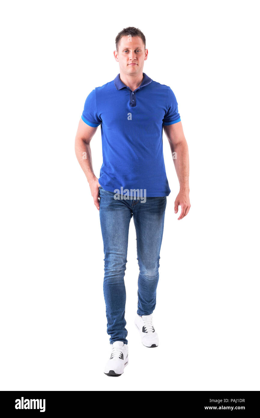 Front view of confident young adult man walking forwards and looking at ... Front view of confident young adult man walking forwards and looking at ...