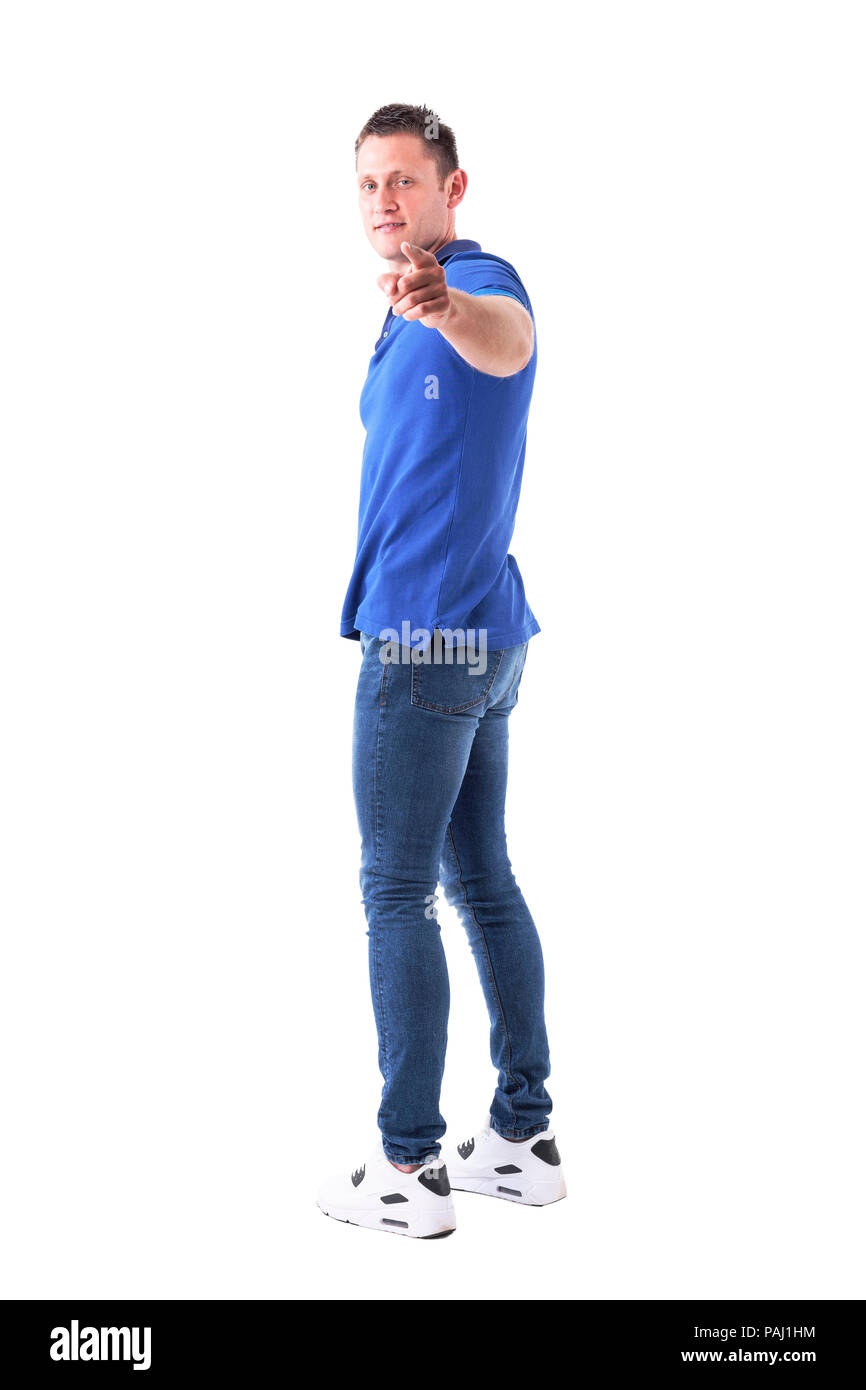 Side view of happy young adult man turning towards camera pointing ...