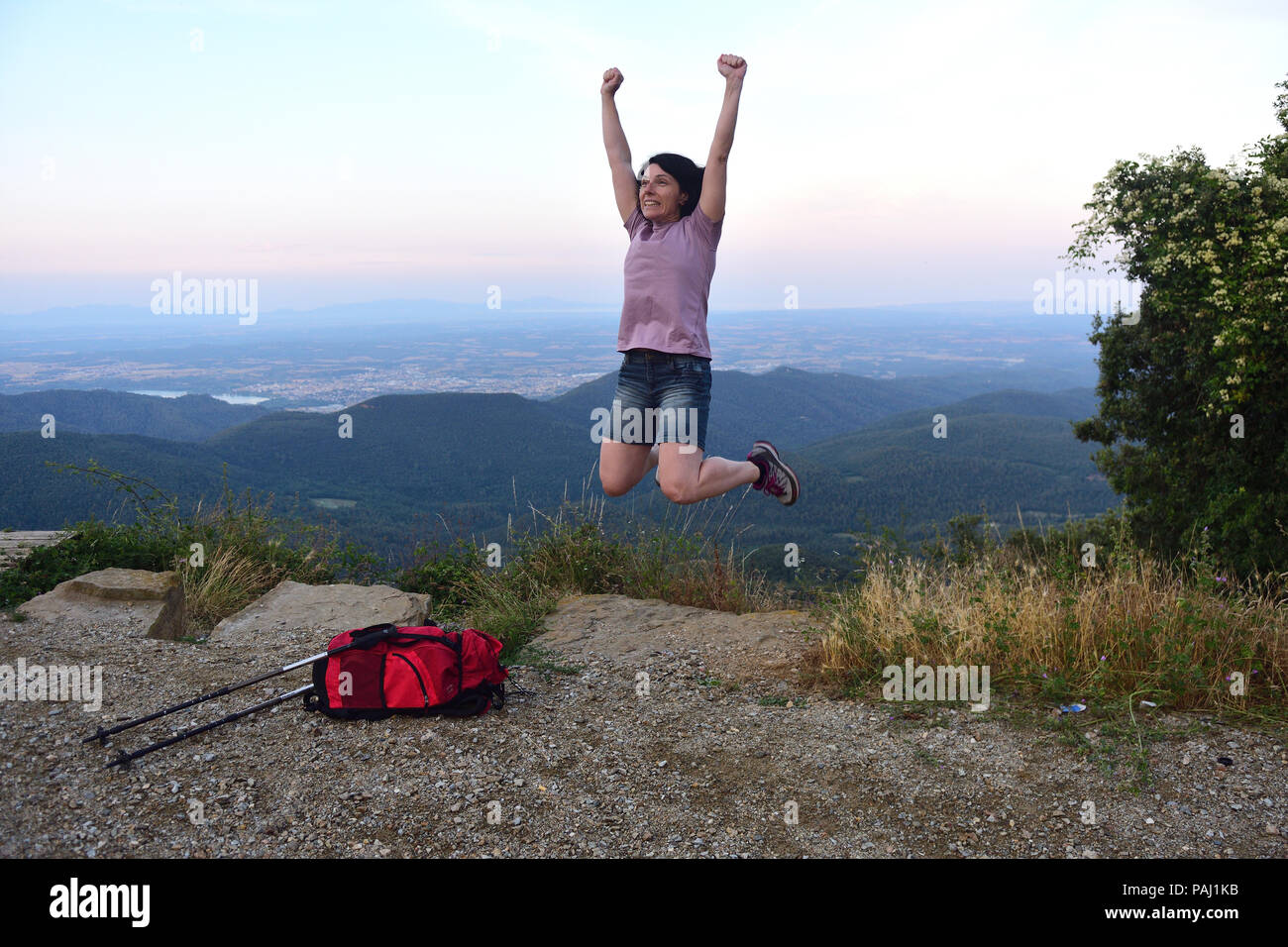happy woman who jumps when she has reached the top Stock Photo - Alamy
