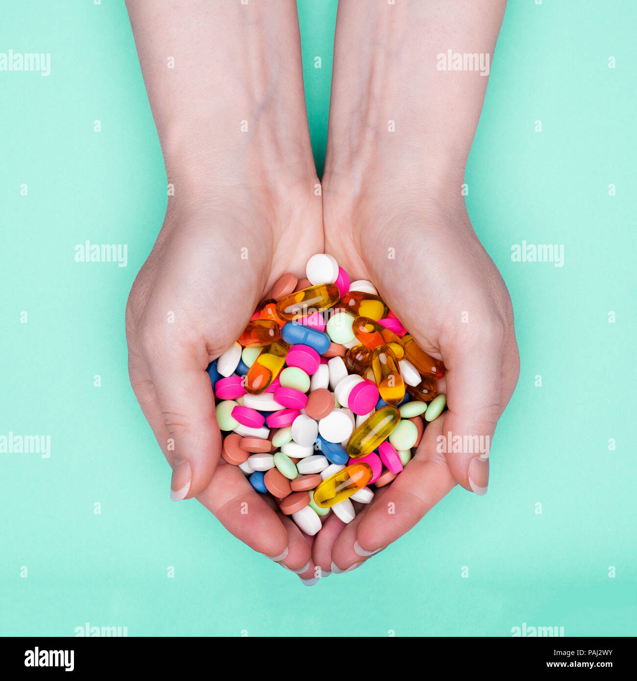 Close up of female hands holding heap of colorful medication pills over ...