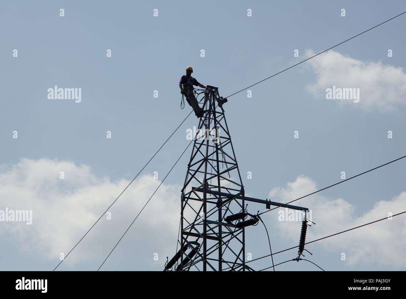 Electrician repair of electric power system. Electrician climbing poles ...