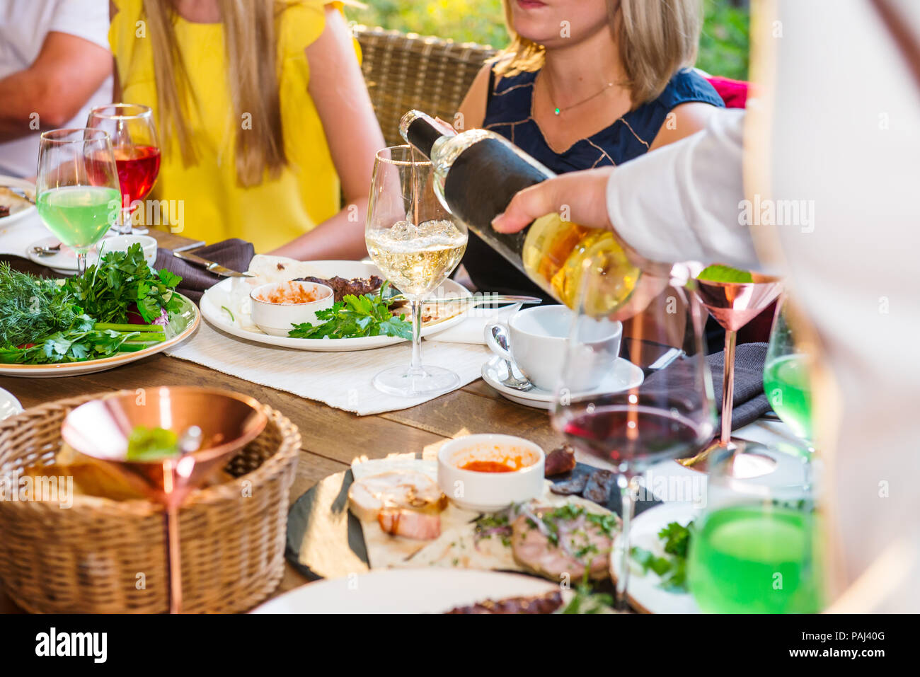 Professional waiter in uniform serving wine to guests of event ...