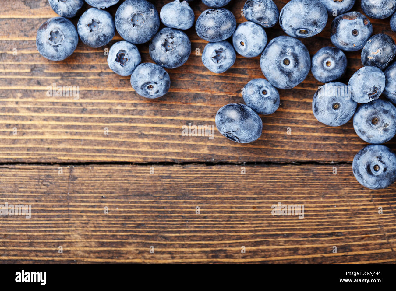 blueberry is scattered as a background on a wooden table. place for ...
