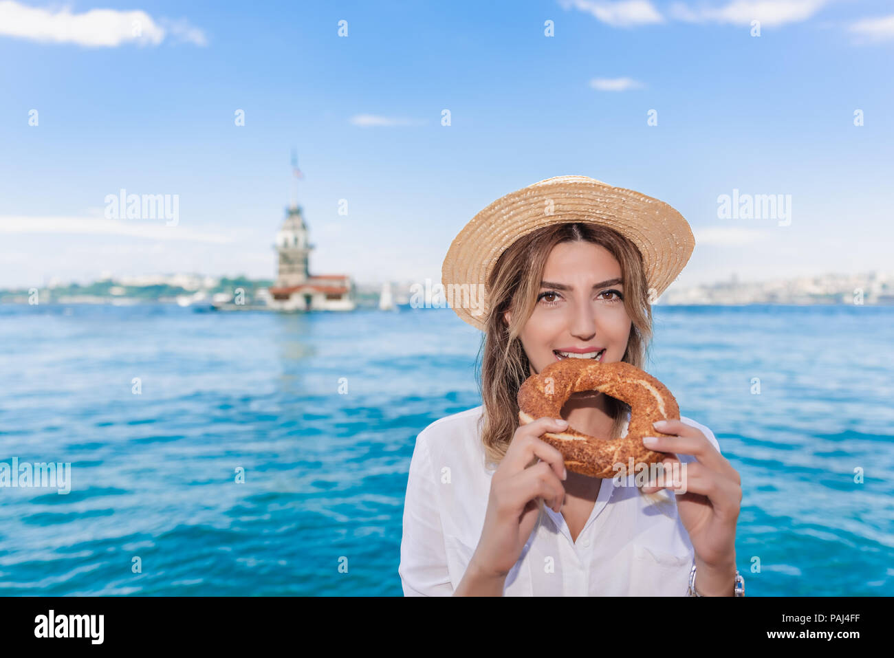 Beautiful woman traveler eats traditional Turkish street food simit ...