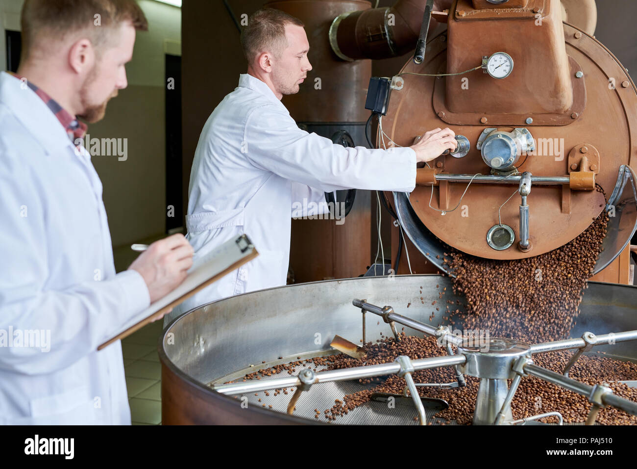 Workers Operating Roasting Machine Stock Photo - Alamy