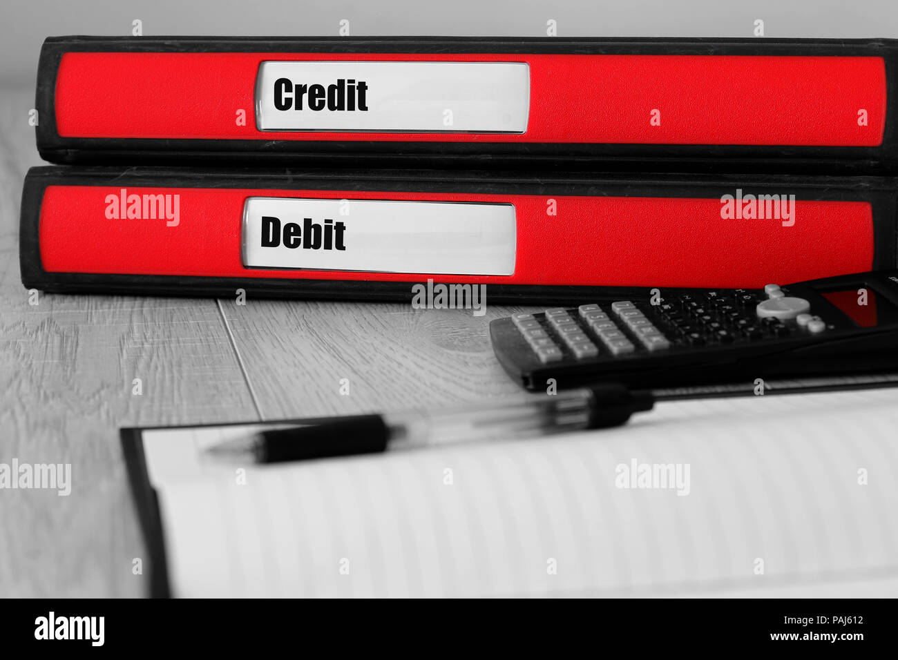 Red folders with credit and debit written on the label on a desk with ...