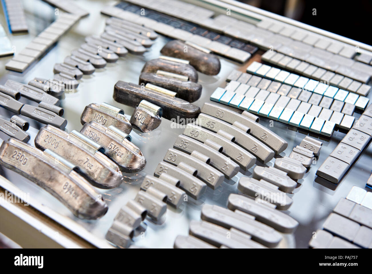 Balancing weights for car wheels in shop Stock Photo - Alamy