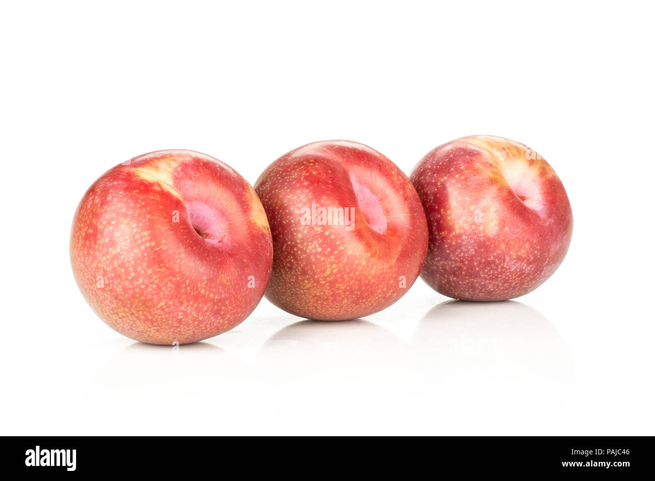 Group of three whole fresh pluot interspecific plums variety in a row ...