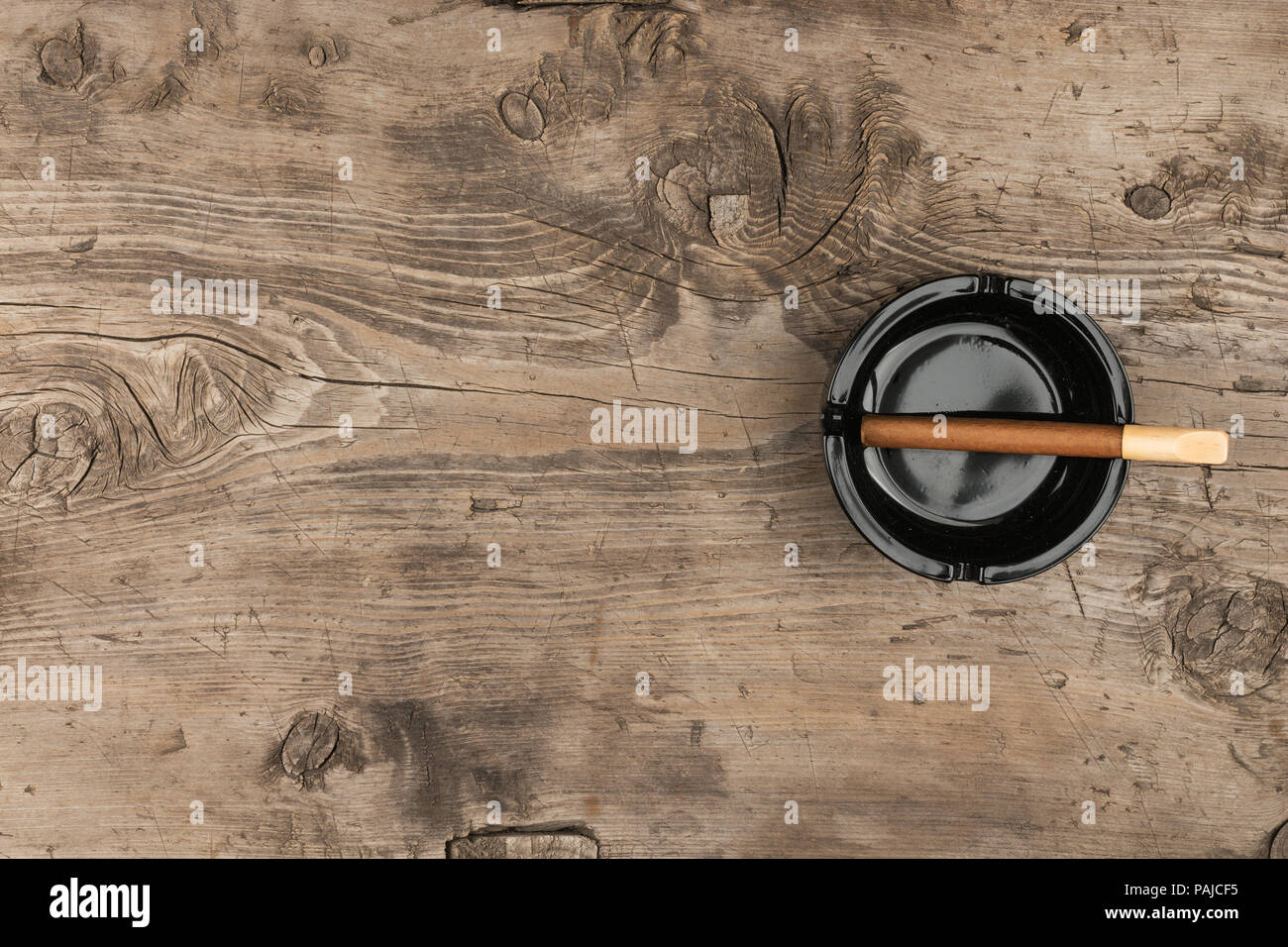 Cigar in an ashtray on a old wooden desk, with a place for your text ...