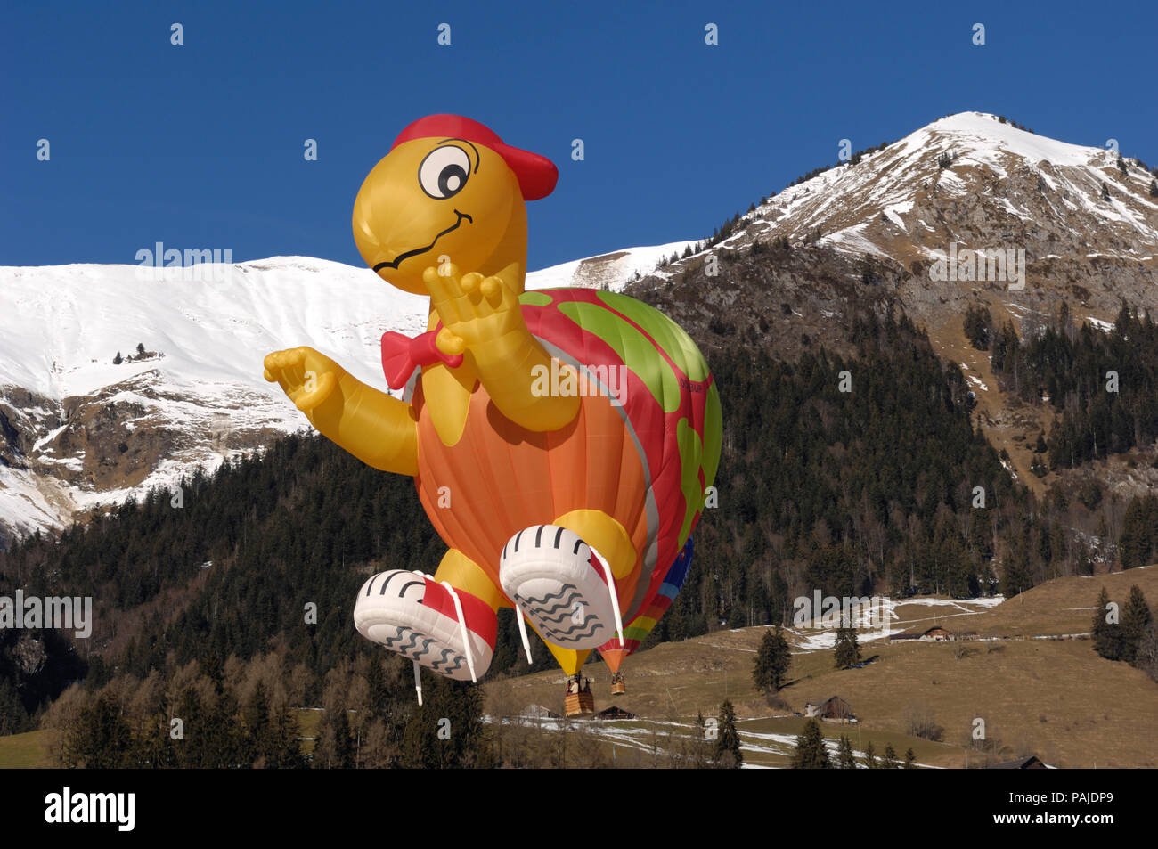 a Cameron SS-120 Turtle special shape hot-air balloon flying with trees ...