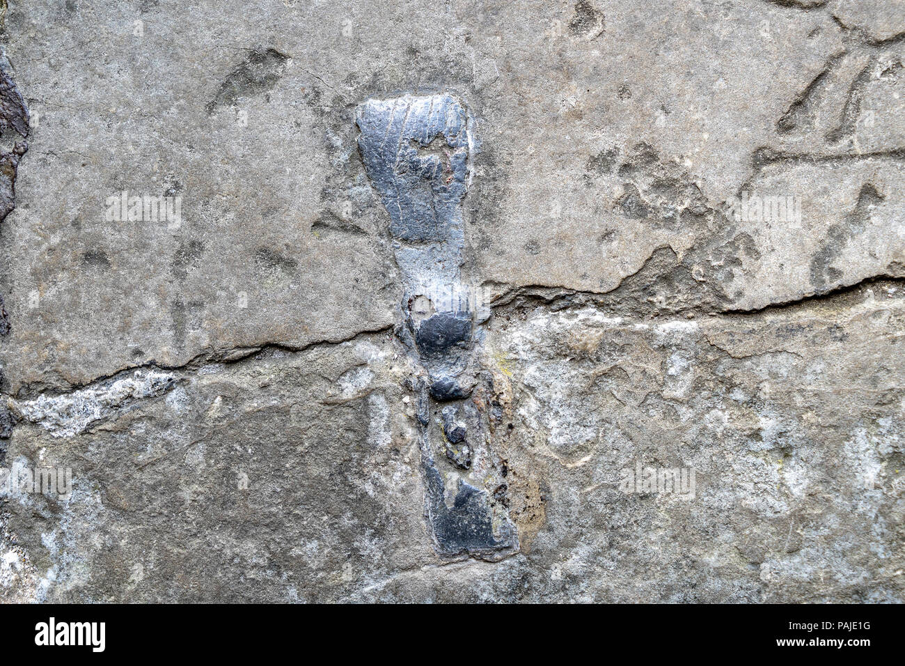 Metal insert brace holding a piece of cracked stone together Stock ...