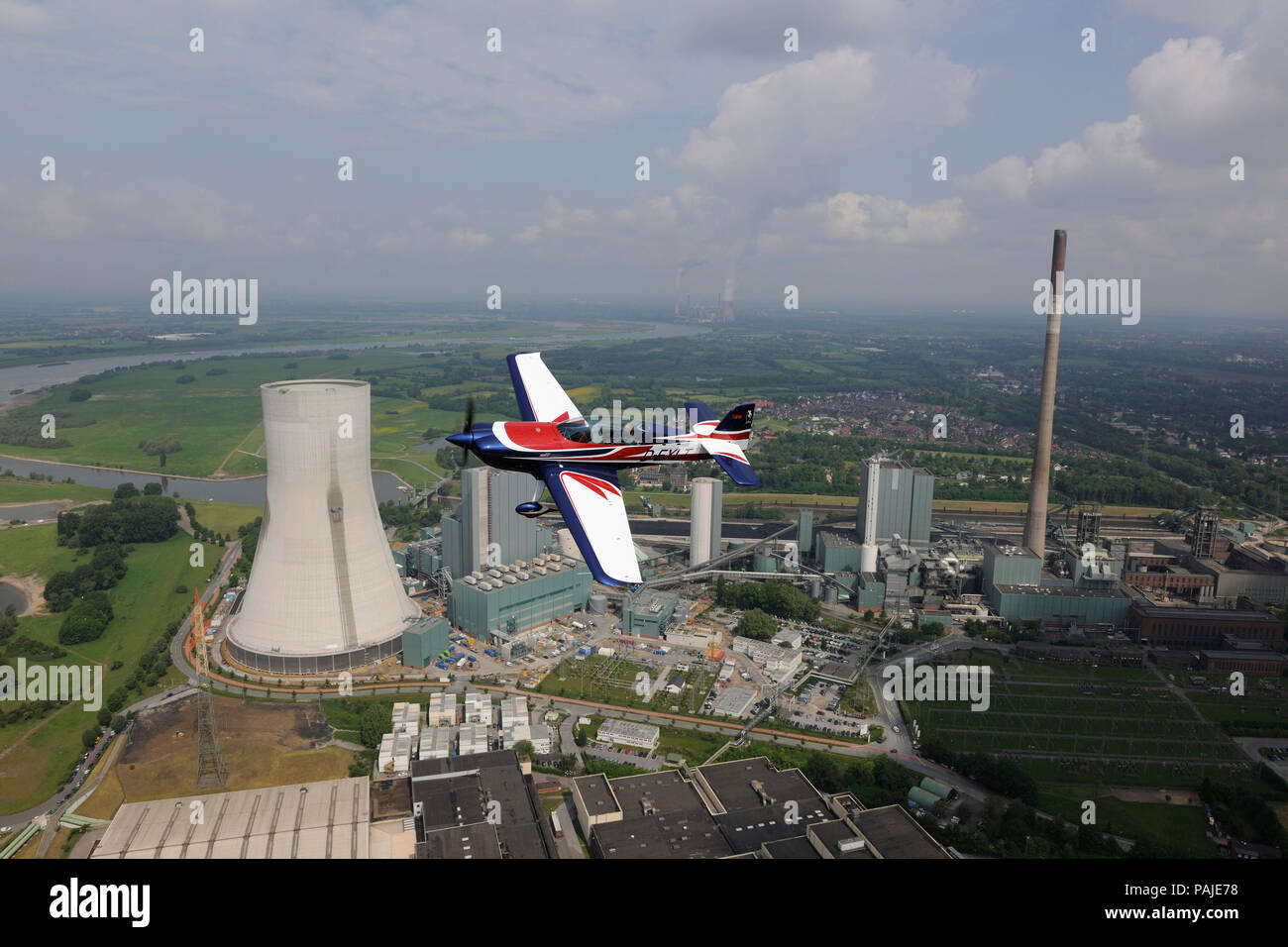 Doug Vayda flying the prototype Extra EA-330LT over a factory in the ...