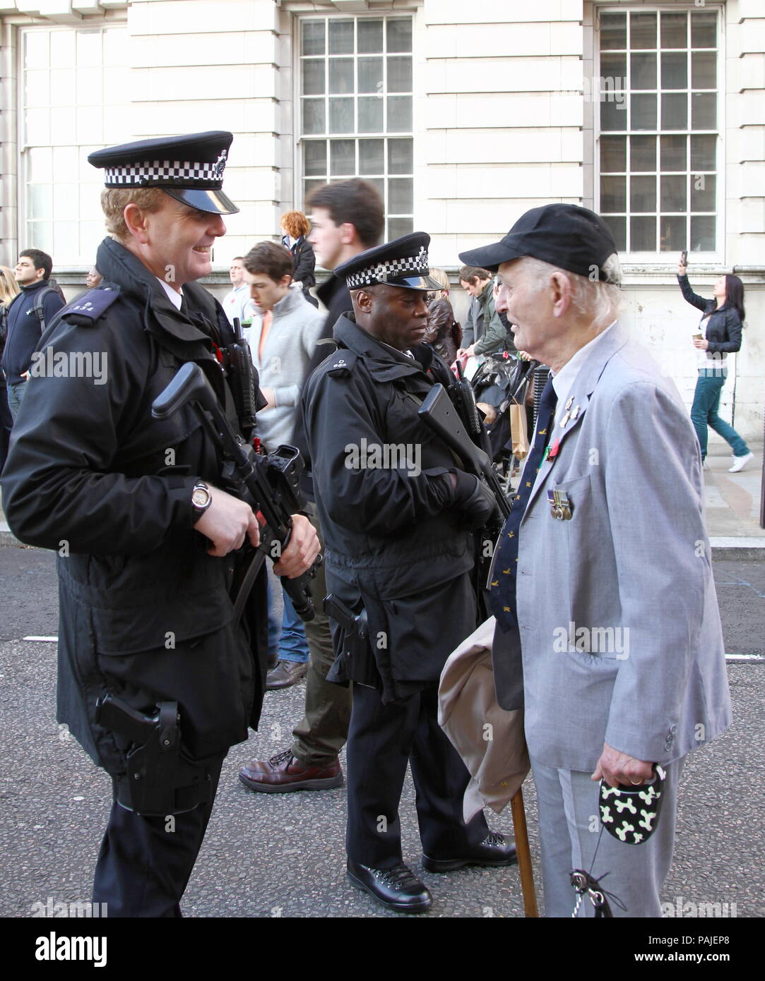 Police public relations. Armed police talk to a member of the public in ...