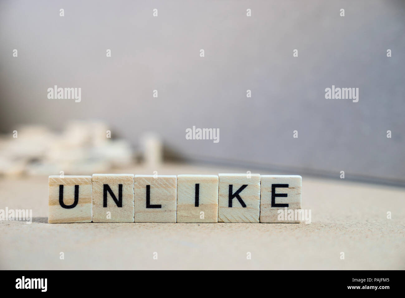 unlike word written on wood block Stock Photo - Alamy