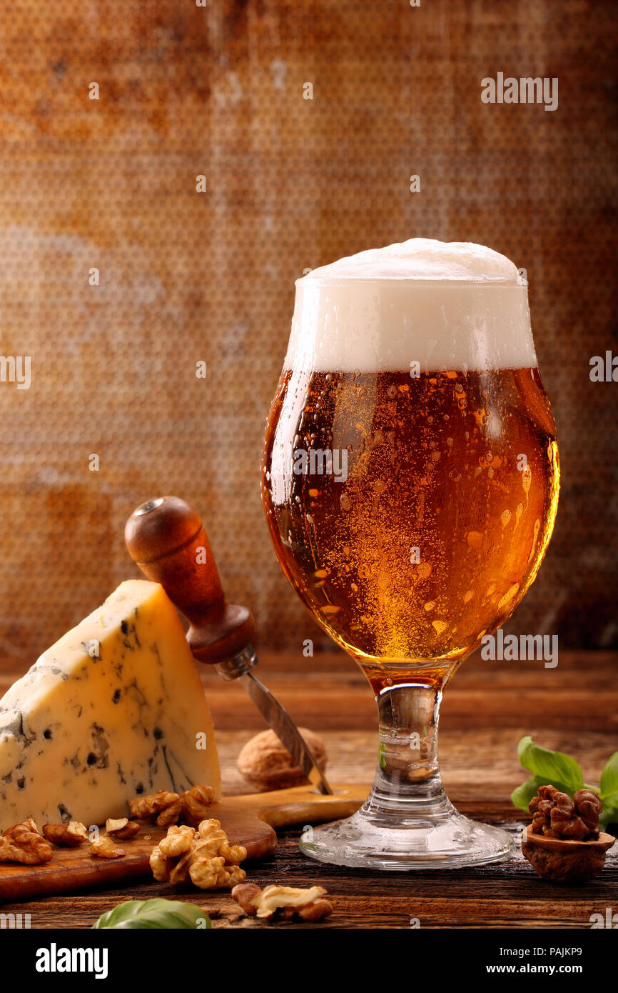 Blue cheese appetizer and beer on brown vintage background and space ...