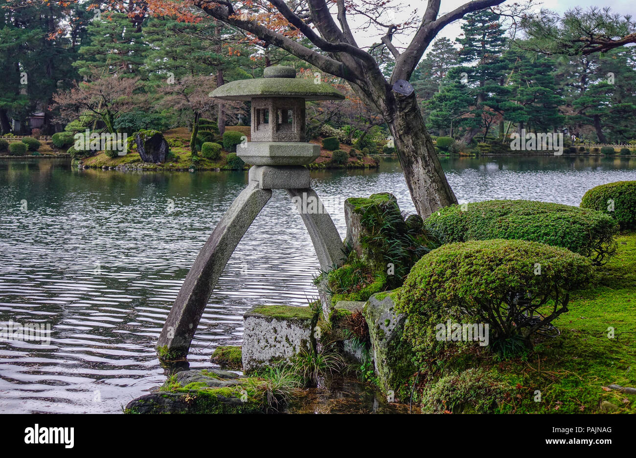 Famous Kotoji two-legged stone lantern beside pond at Kenroku-en garden ...