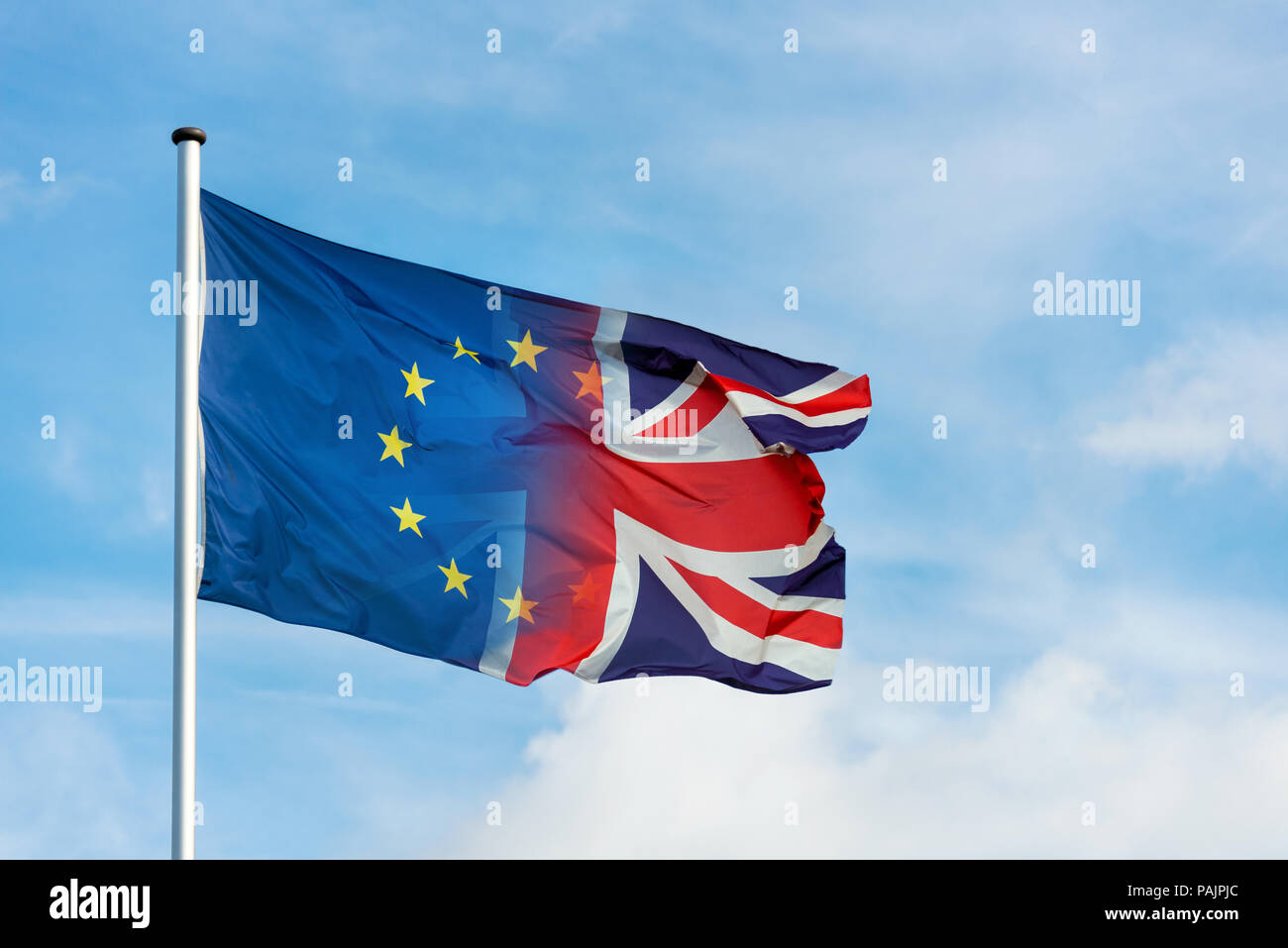 Merging european and british flag in front of blue sky as a symbol for ...
