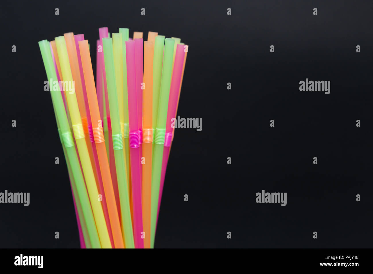 Closeup of bright colorful single use disposable plastic straw bunch as ...