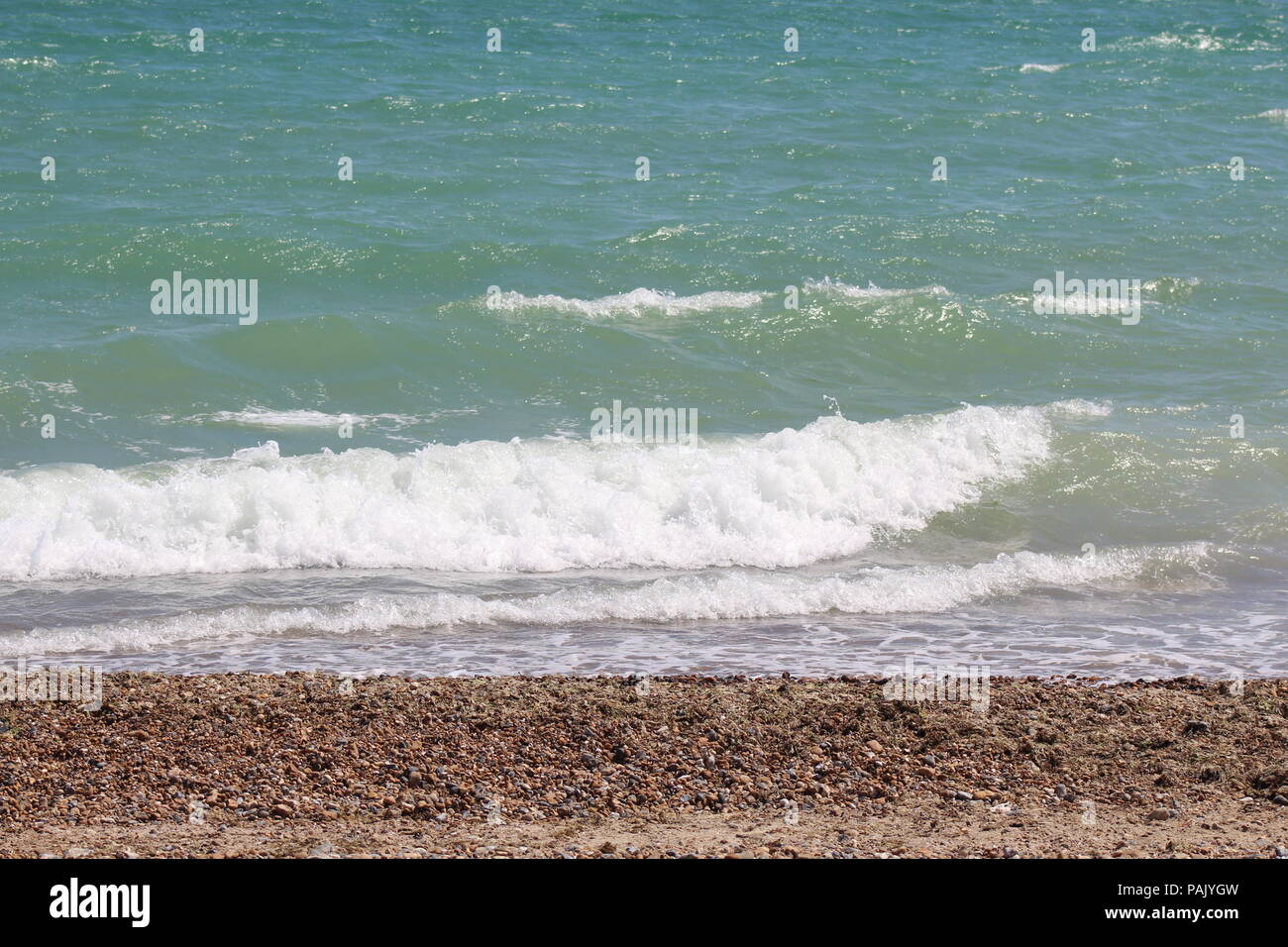 Tide coming in on pebble beach Stock Photo - Alamy