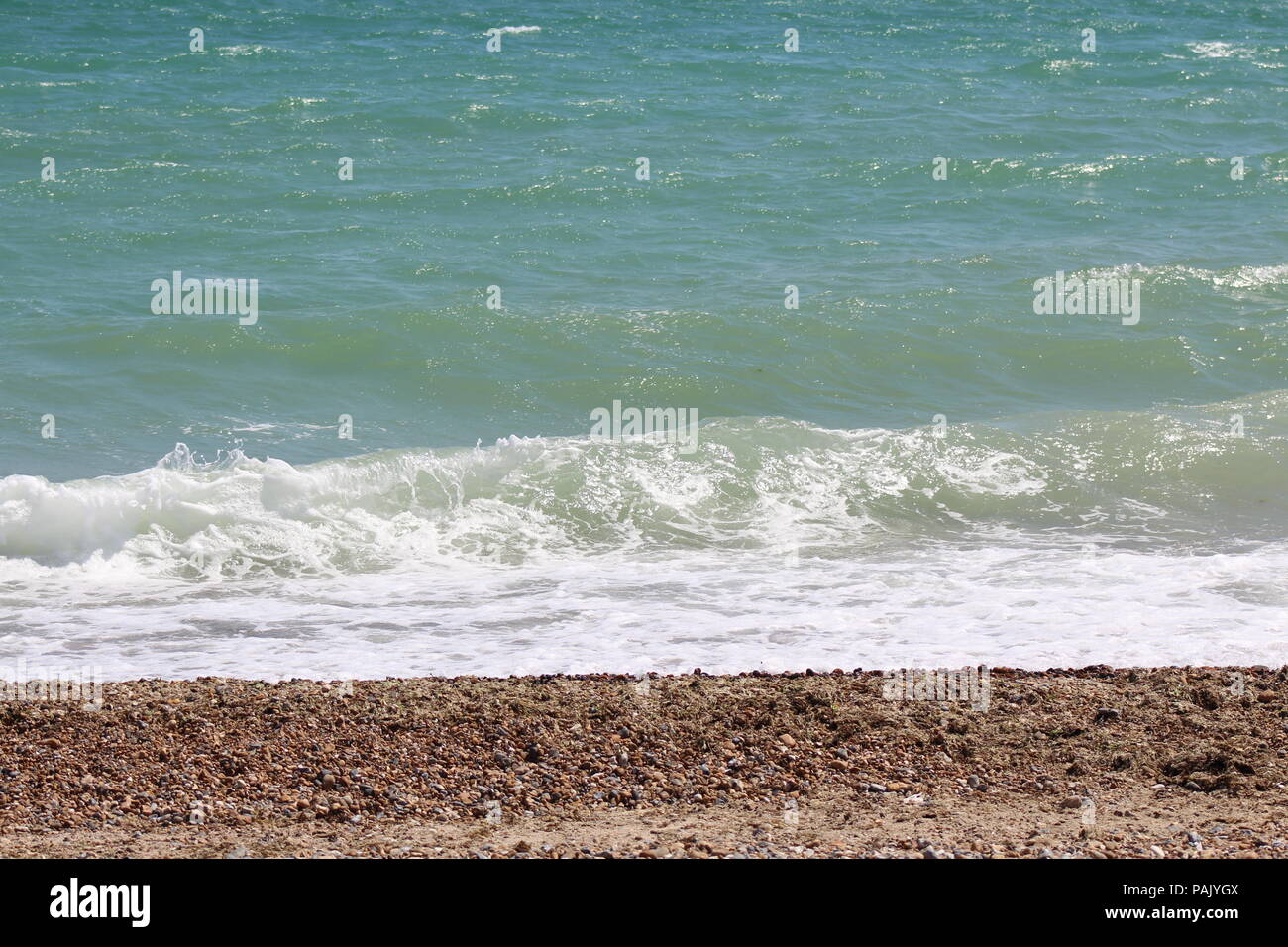 Tide coming in on pebble beach Stock Photo - Alamy