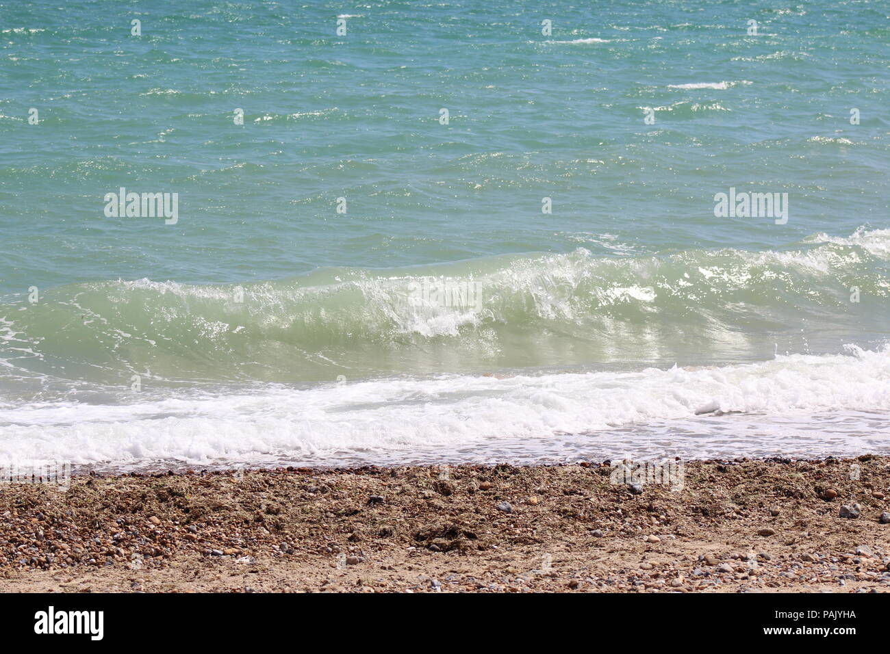 Tide coming in on pebble beach Stock Photo - Alamy