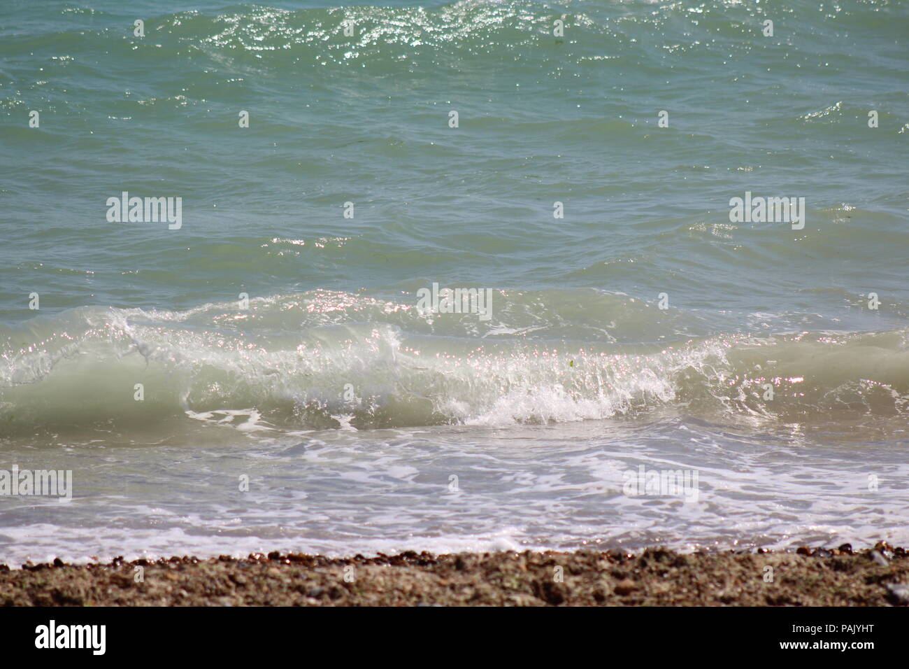 Tide coming in on pebble beach Stock Photo - Alamy