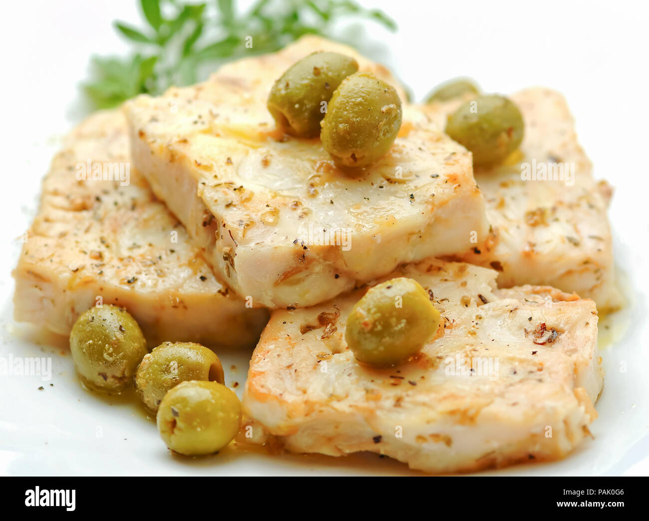 Cod fillet with green olives on white background Stock Photo - Alamy