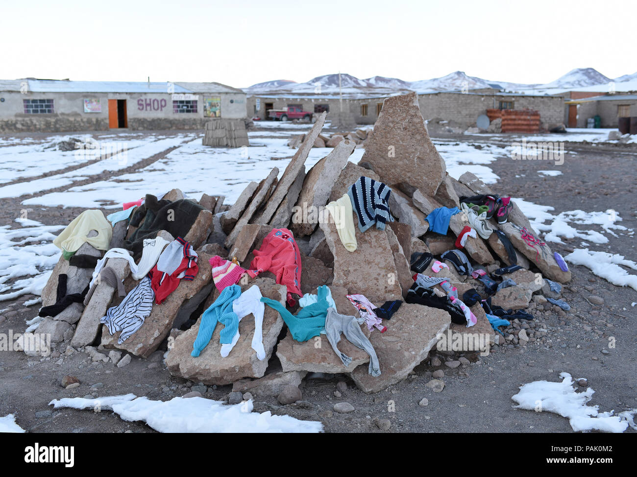 Washed clothes of a family drying on a pile of cement debris in the ...