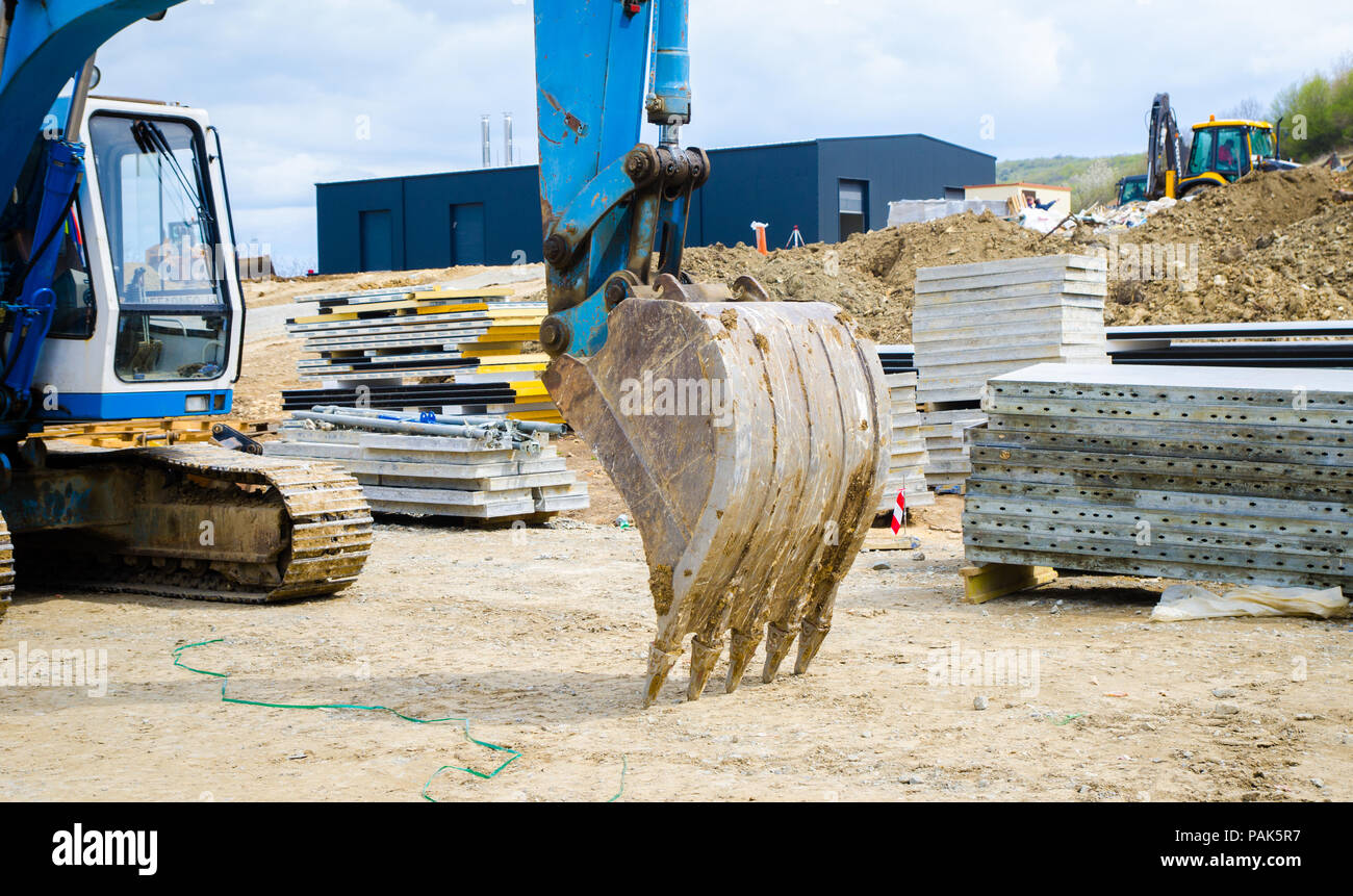 Bucket on a blue excavator standing still on a construction site with ...