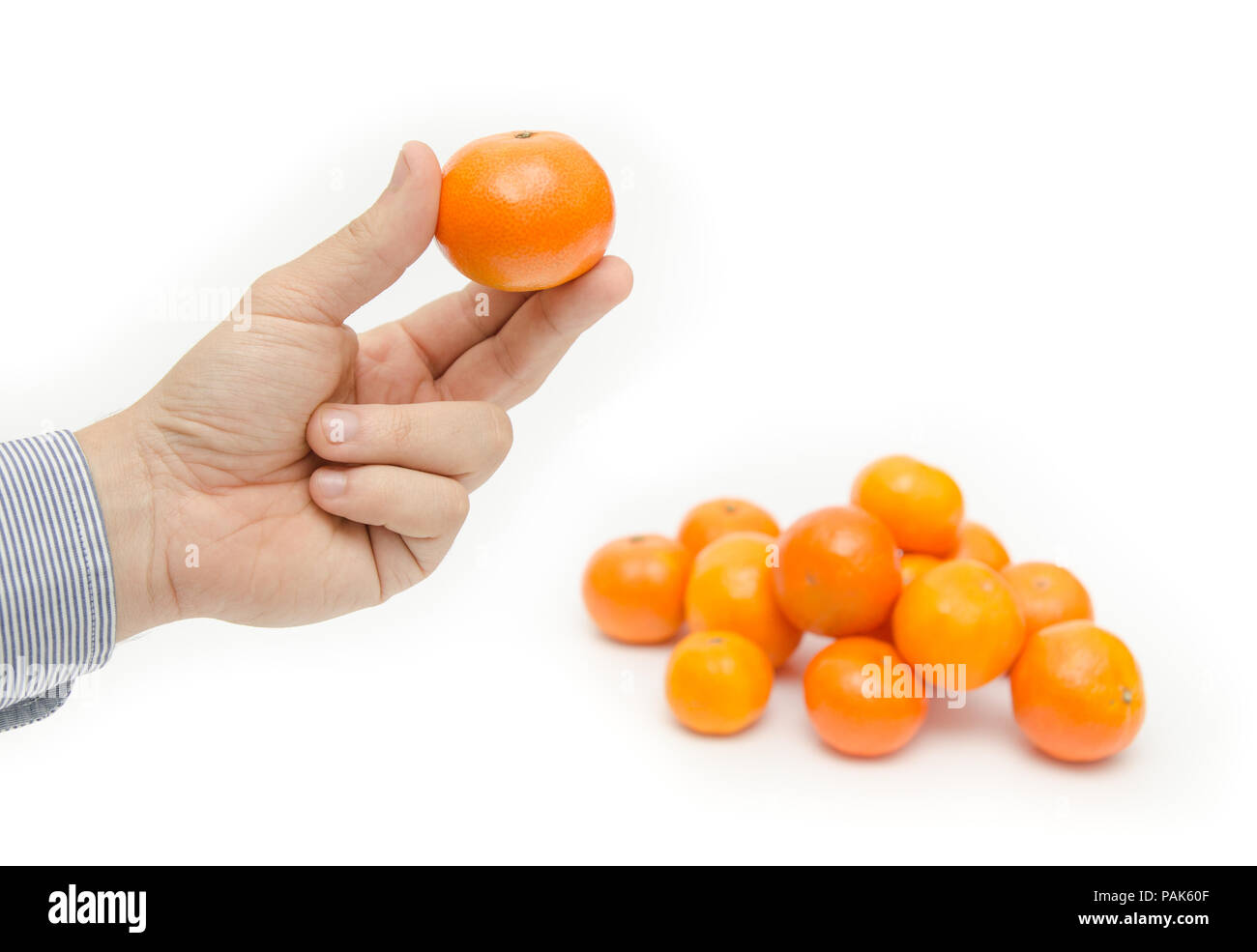 Fresh orange fruit being held with three fingers by a business hand ...