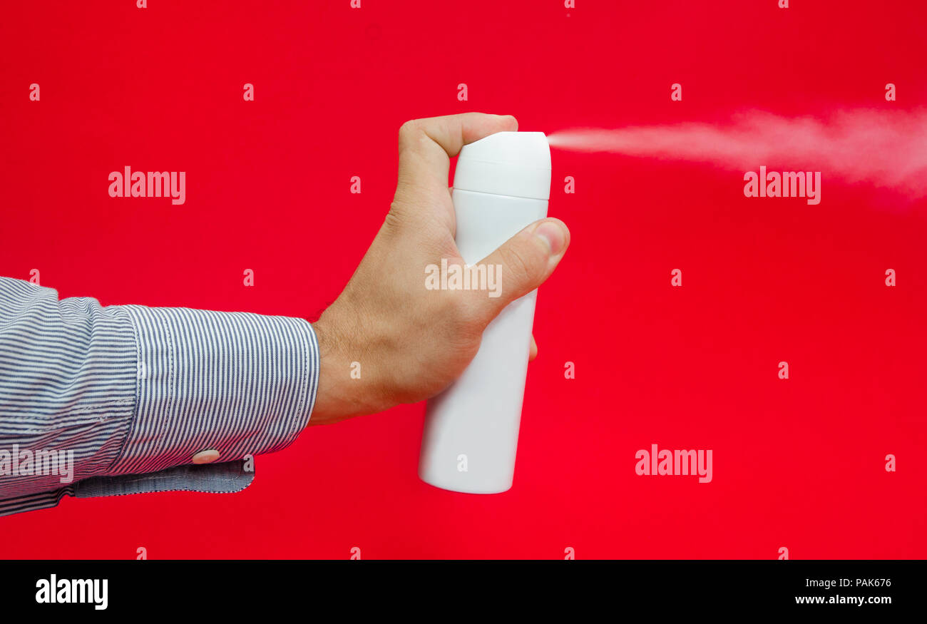 Toxic spray being pulverized from a white can by a business man's hand ...