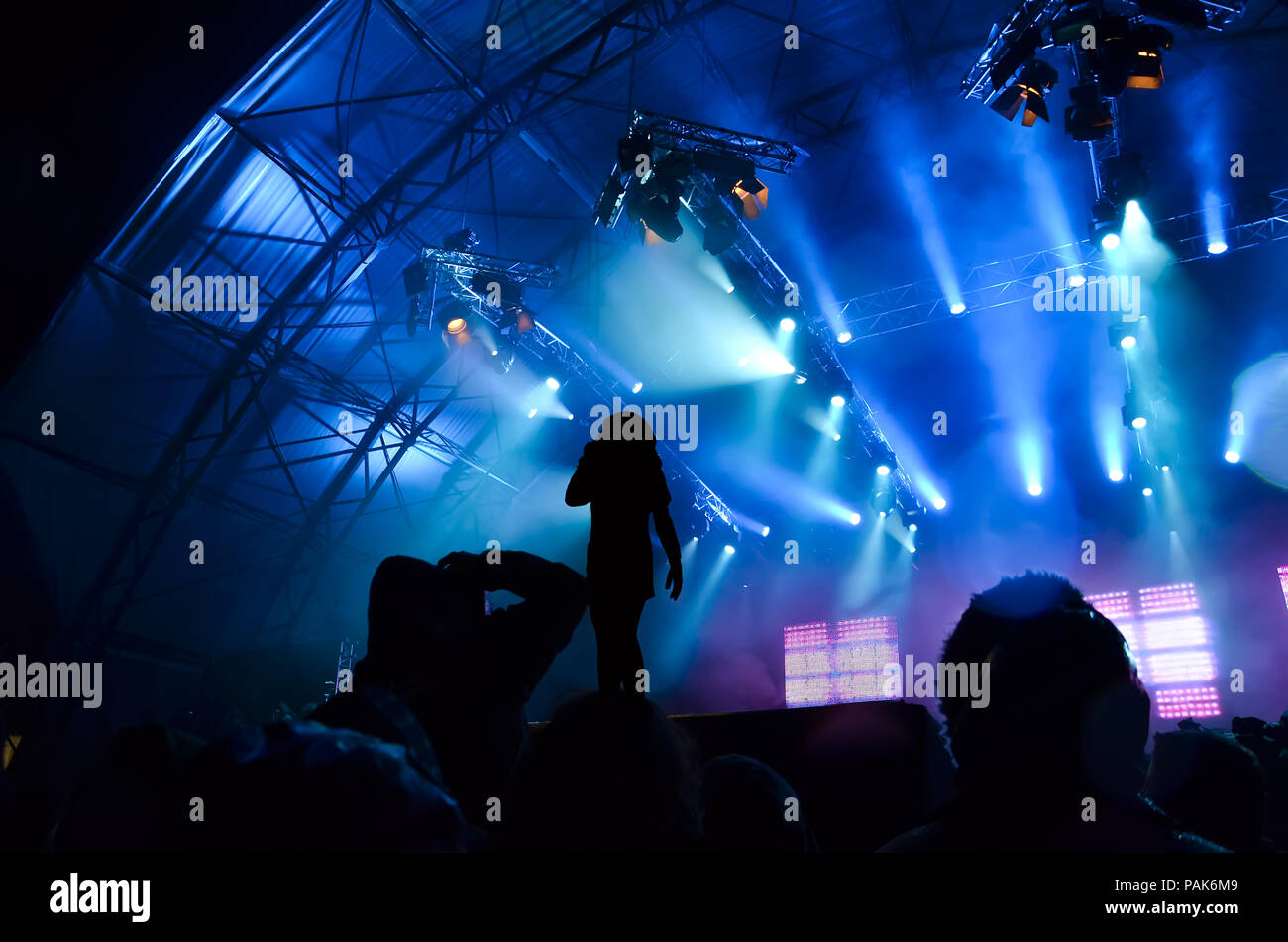 Popular female singer silhouette singing on a stage with blue ...