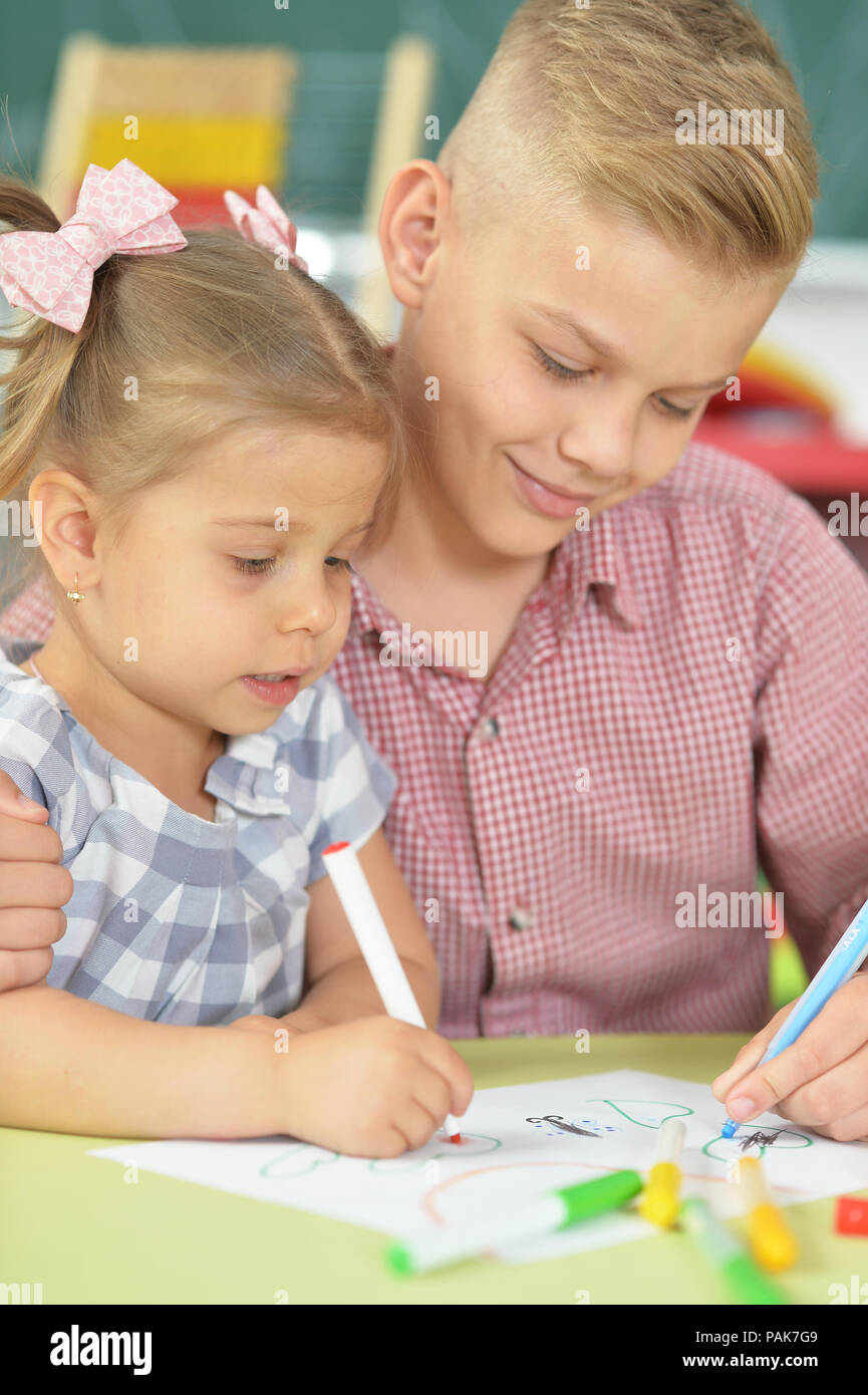 Smiling brother and sister drawing with felt pens Stock Photo - Alamy