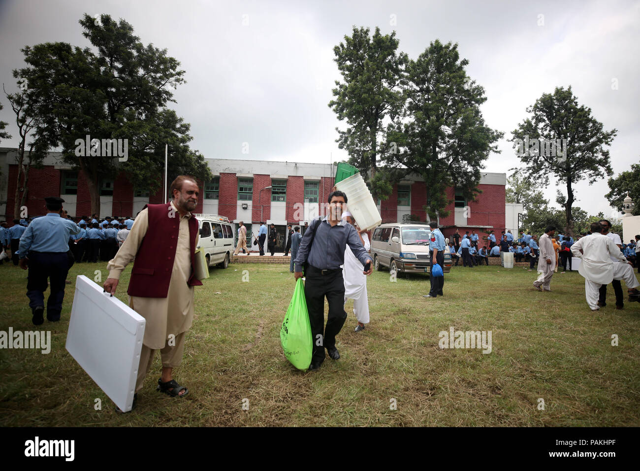 Islamabad, Pakistan. 24th July, 2018. Election officials carry ballot ...