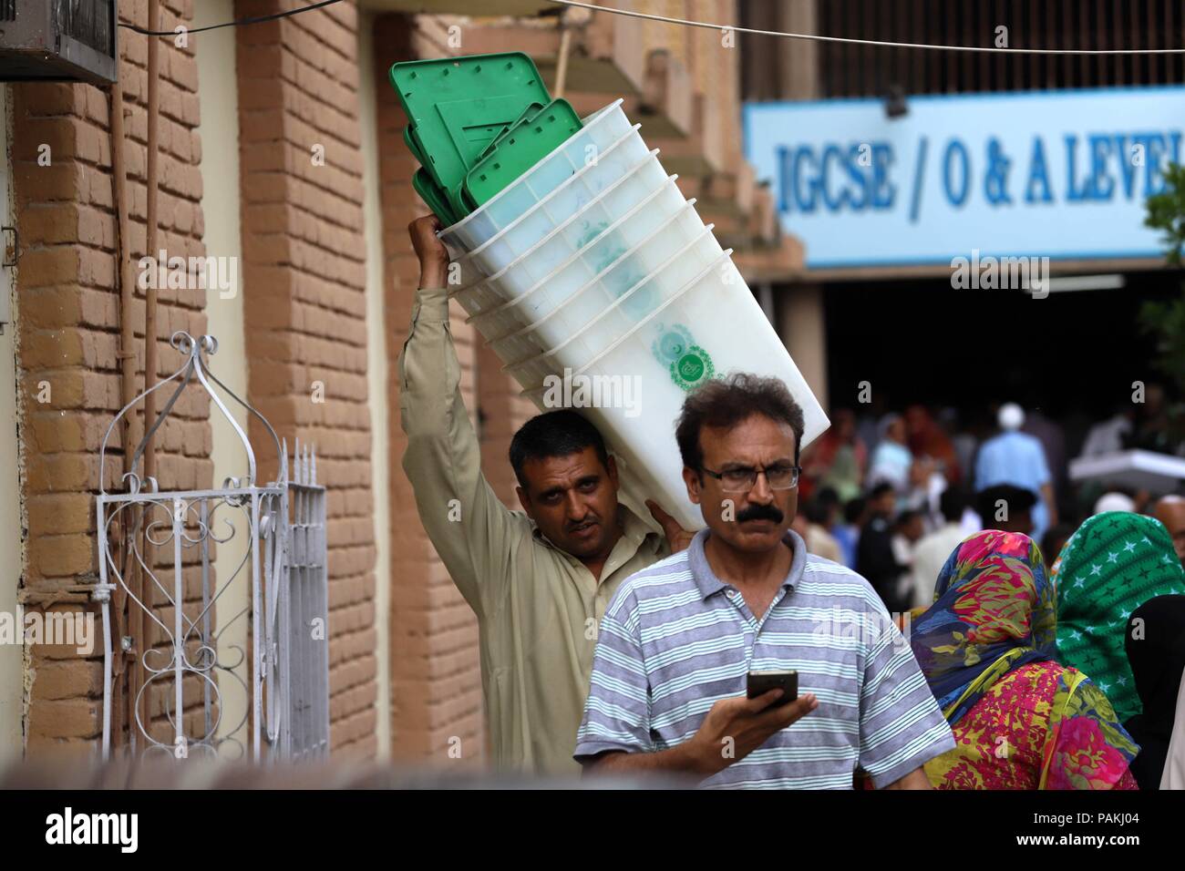 Islamabad, Pakistan. 24th July, 2018. An election official carries ...