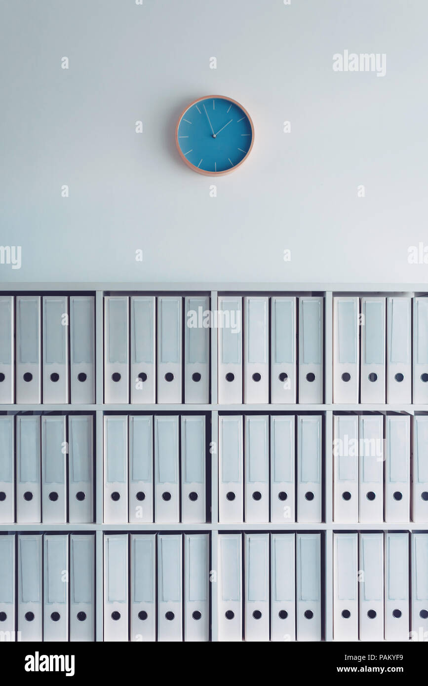 Document ring binders in business office with clock on the wall as ...