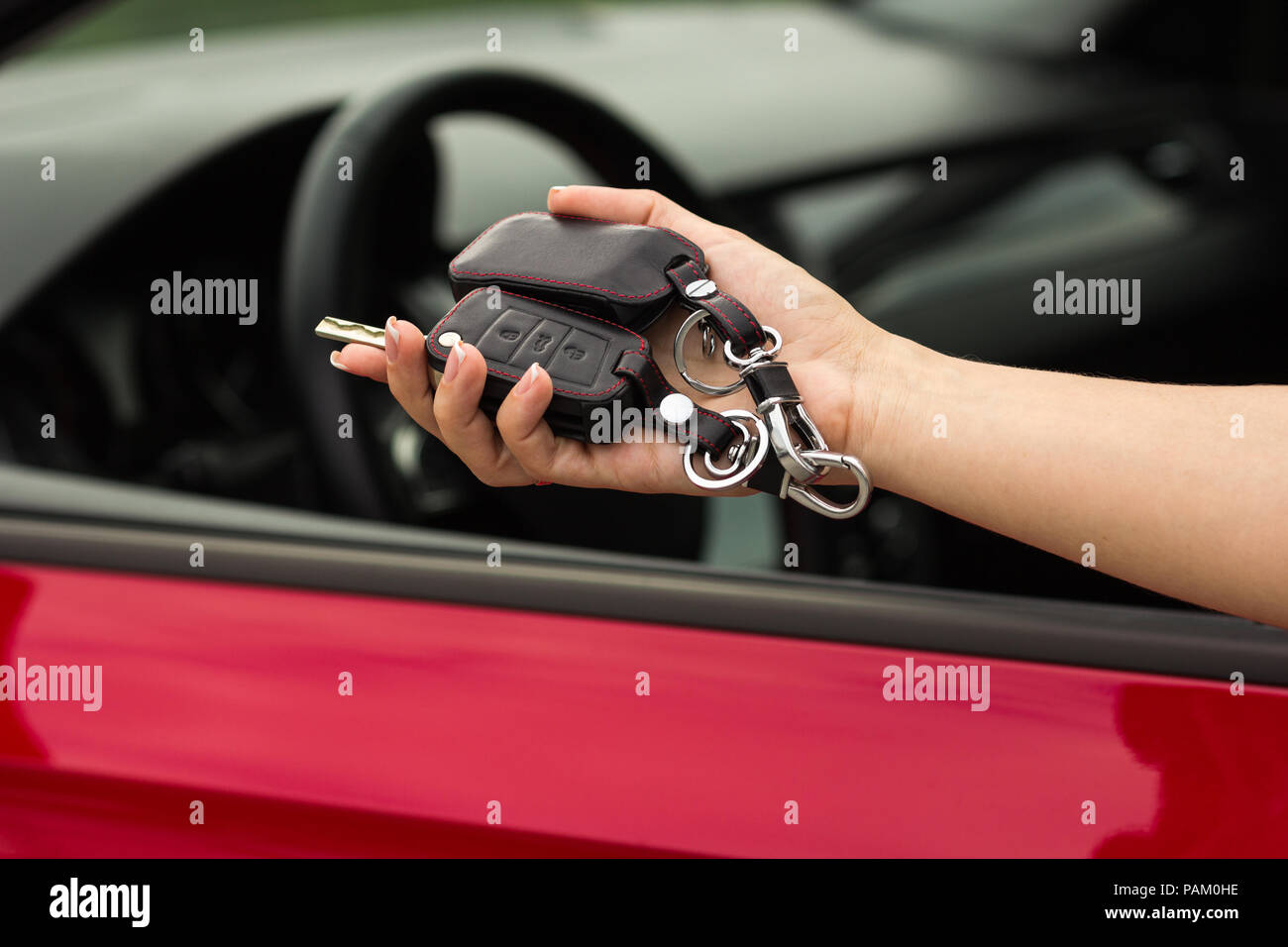 hand of a girl with a car key in hand, on a red car background Stock ...