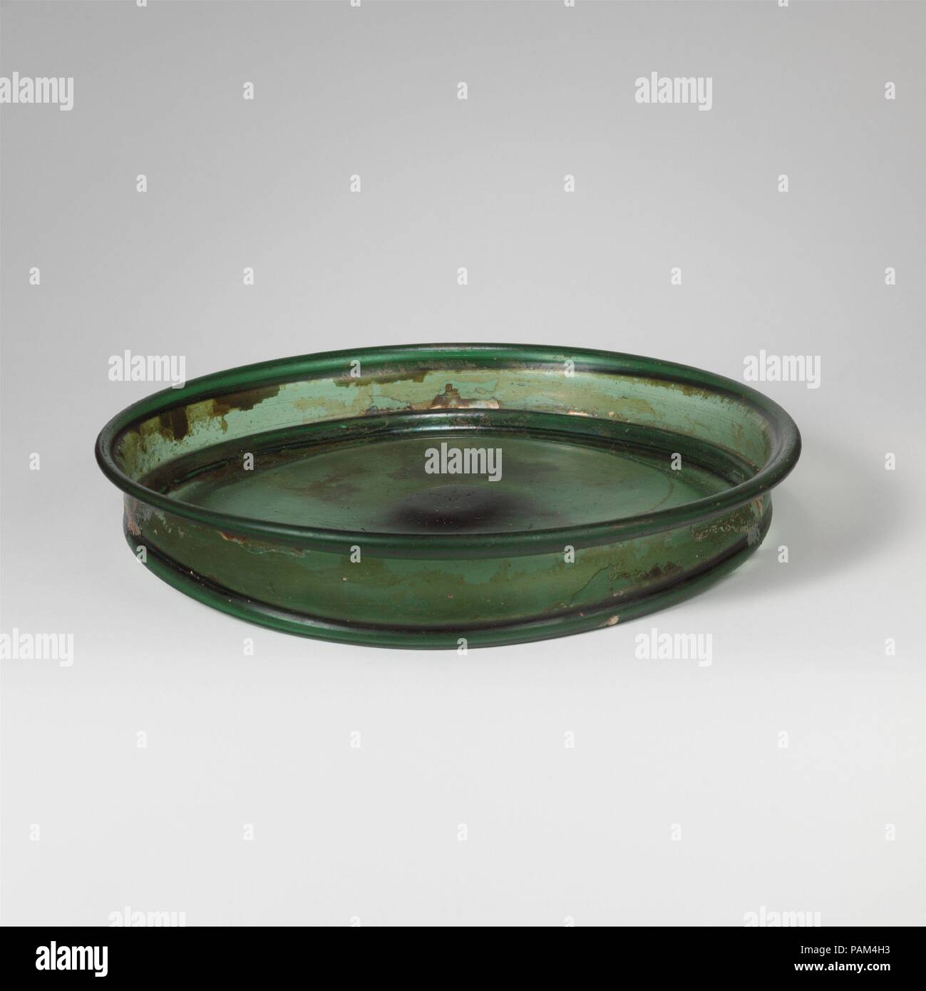 Glass dish. Culture: Roman. Dimensions: H.: 1 3/16 in. (3 cm) Diam.: 7 ...