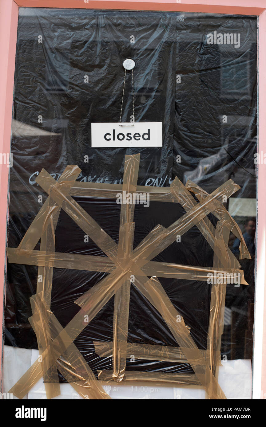 Hackney, London. Closed sign in broken cafe window that has ceased ...